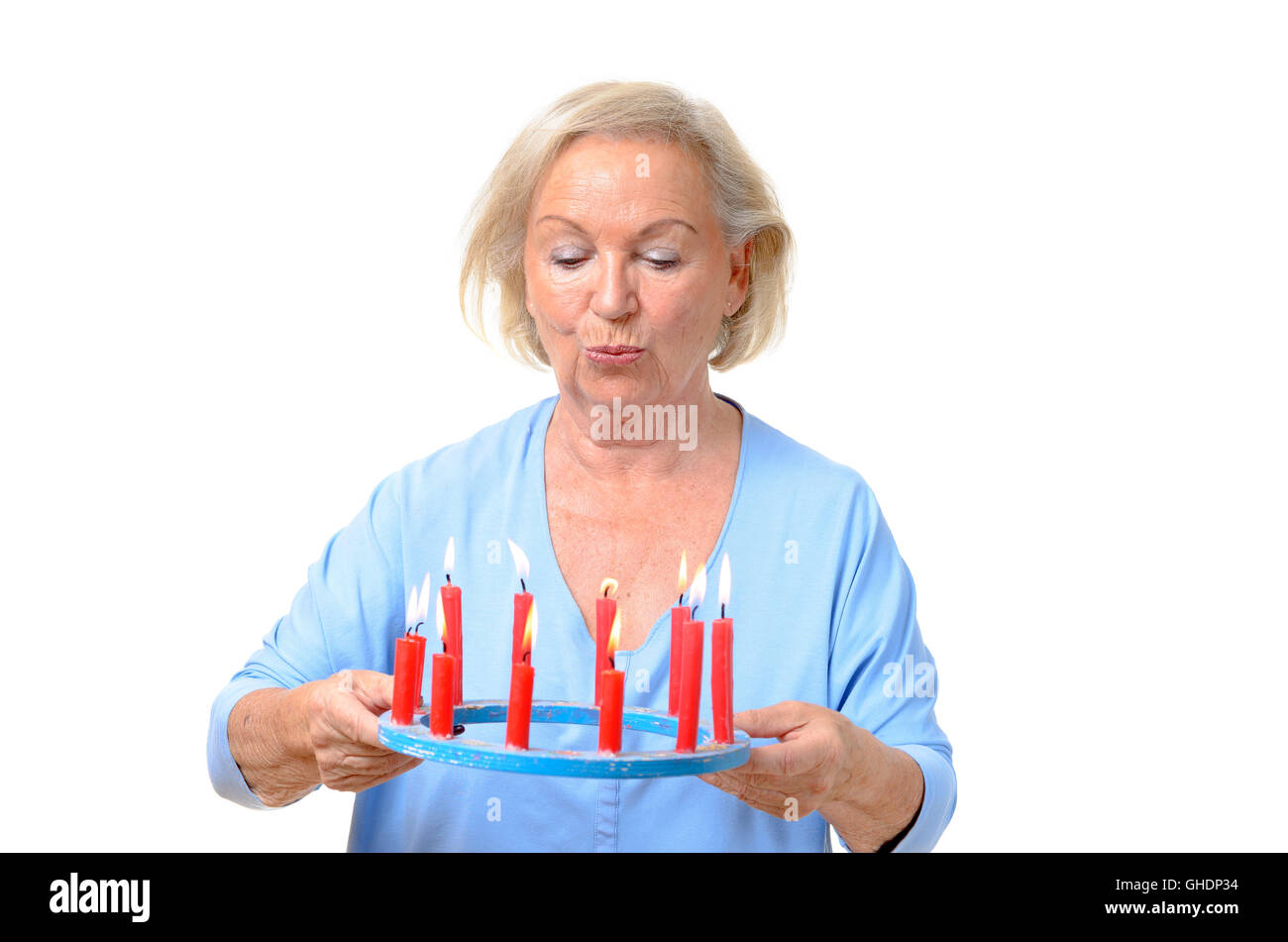 Attractive blond woman holding a ring of festive burning red candles ...