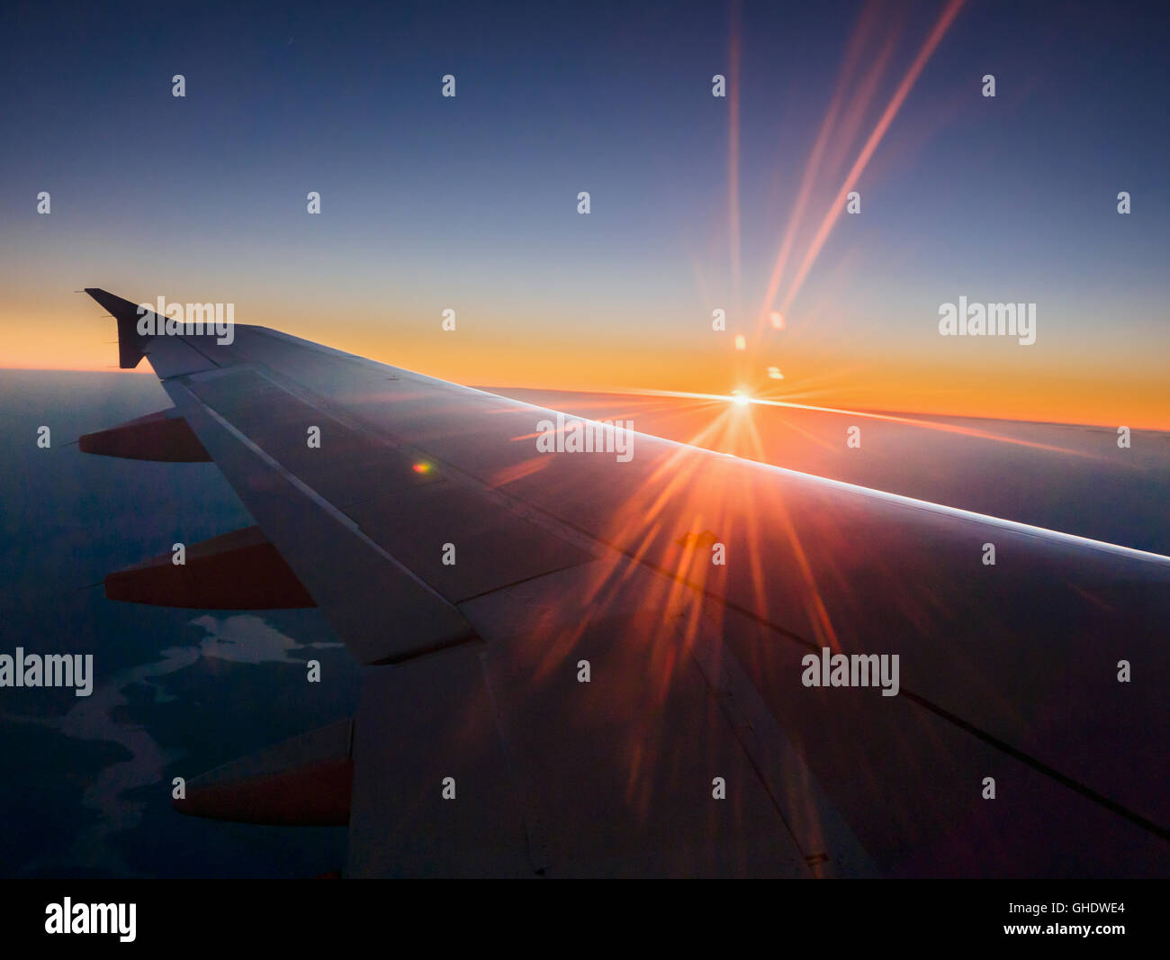 Sunset behind airplane wing in sky Stock Photo - Alamy