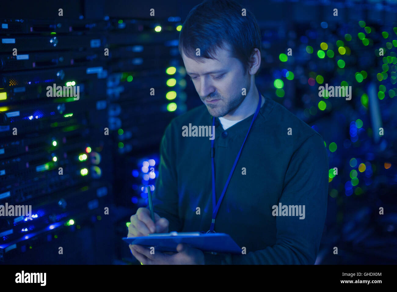 Server room technician taking notes on clipboard Stock Photo - Alamy