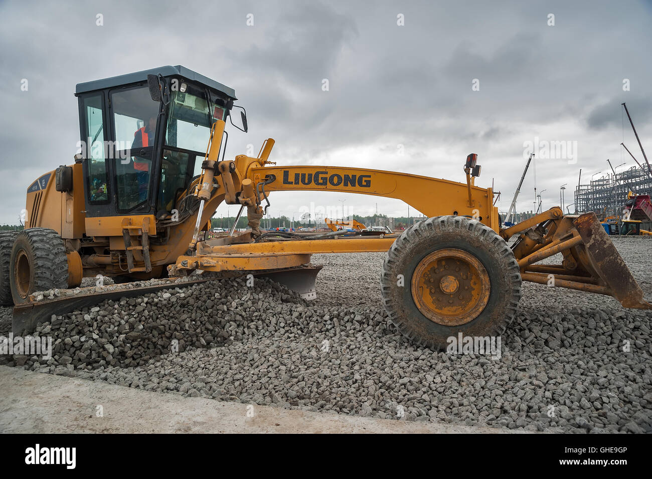 Grader leveling gravel on construction site Stock Photo - Alamy