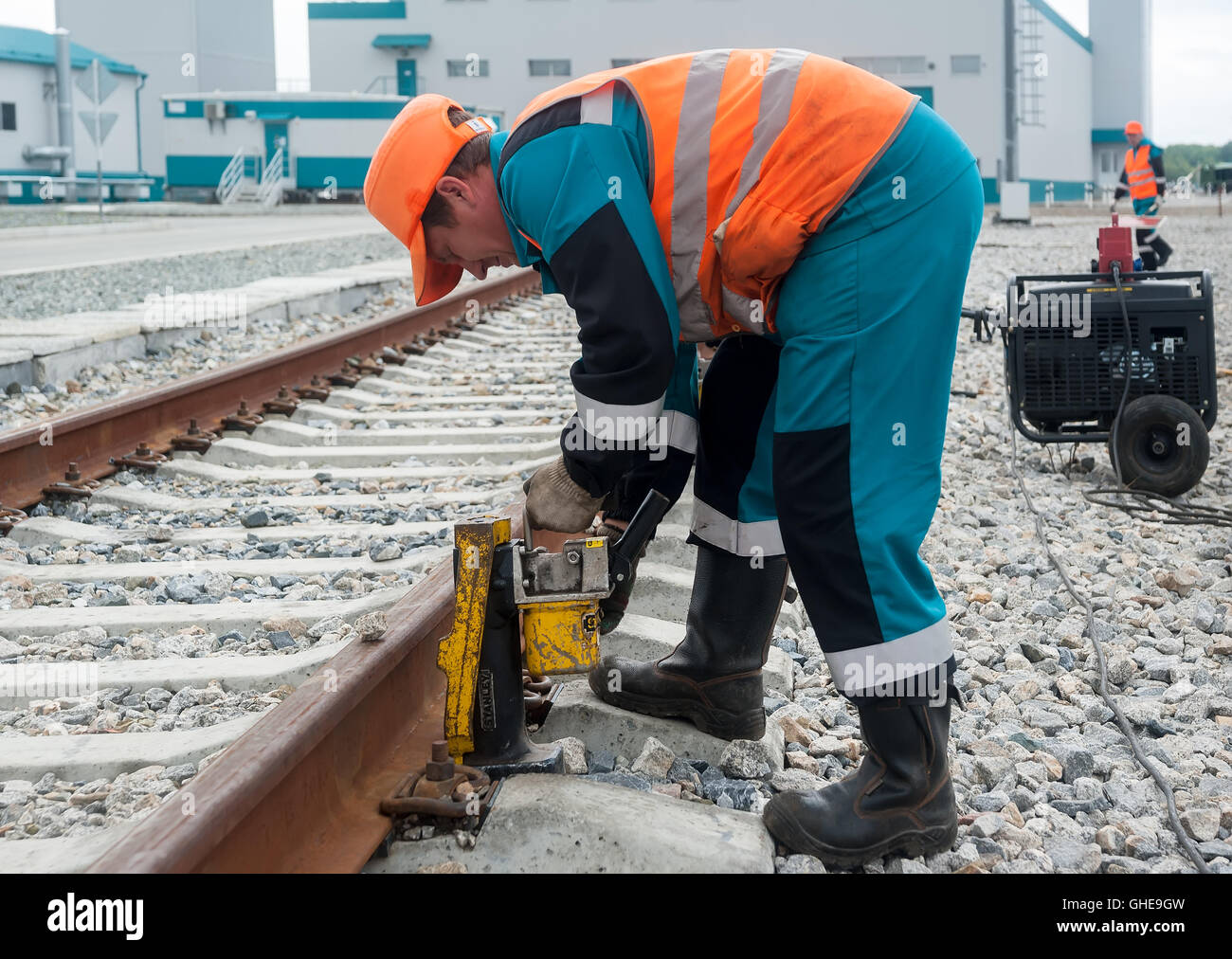 Worker establishes jack for lifting rail Stock Photo - Alamy