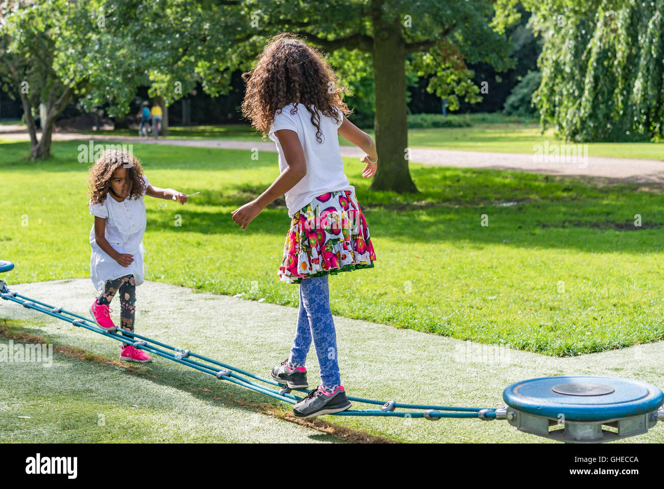 Two kids balancing on a playground Stock Photo - Alamy