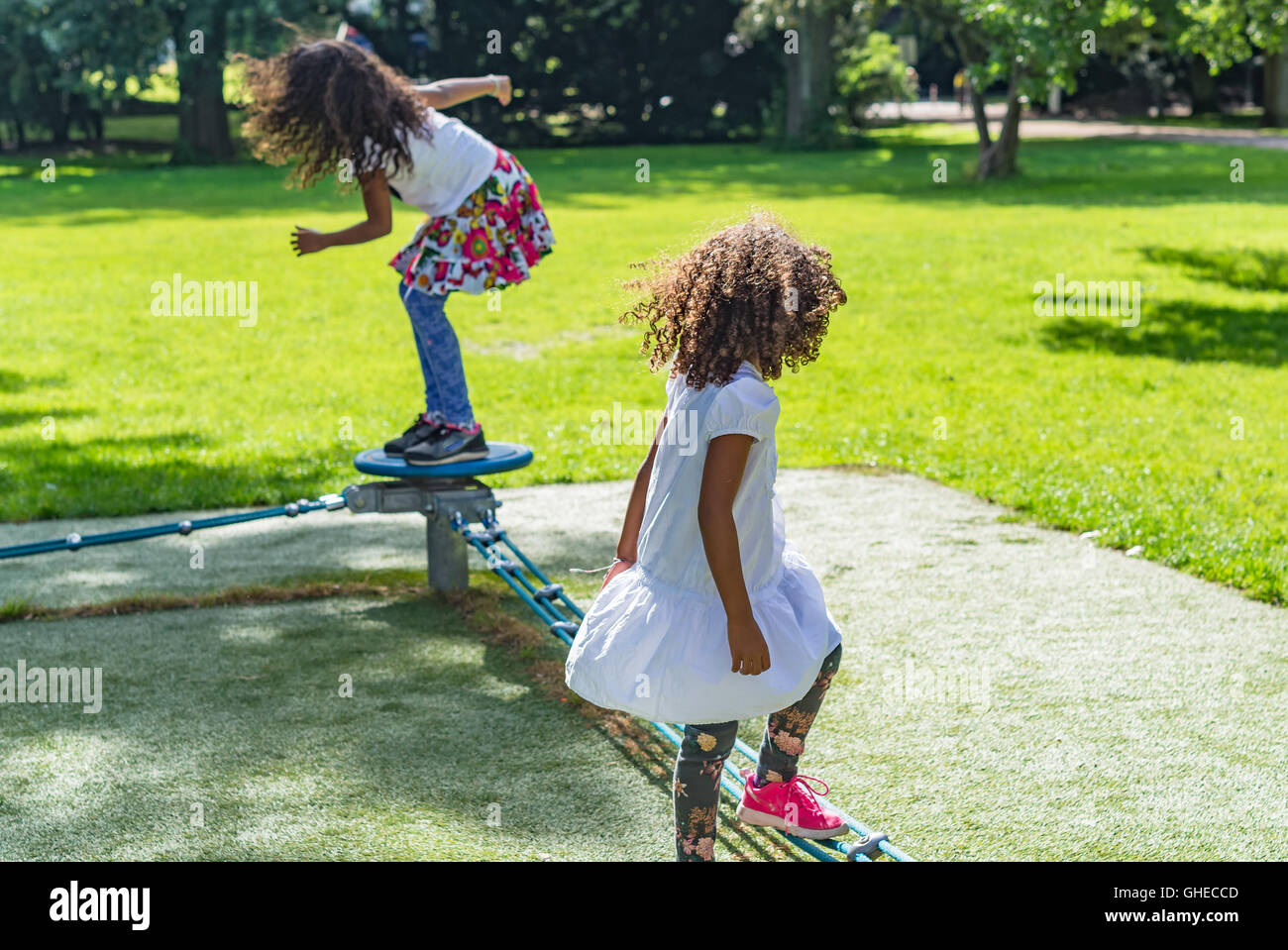 Two kids balancing on a playground Stock Photo - Alamy