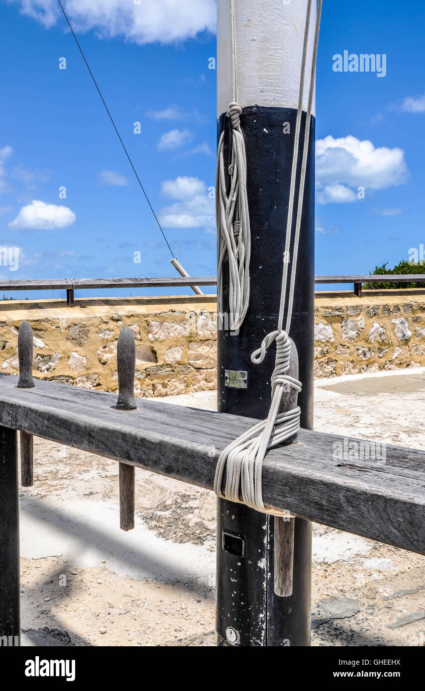 Flagpole with lanyard in figure eight and wooden railing with cleats ...