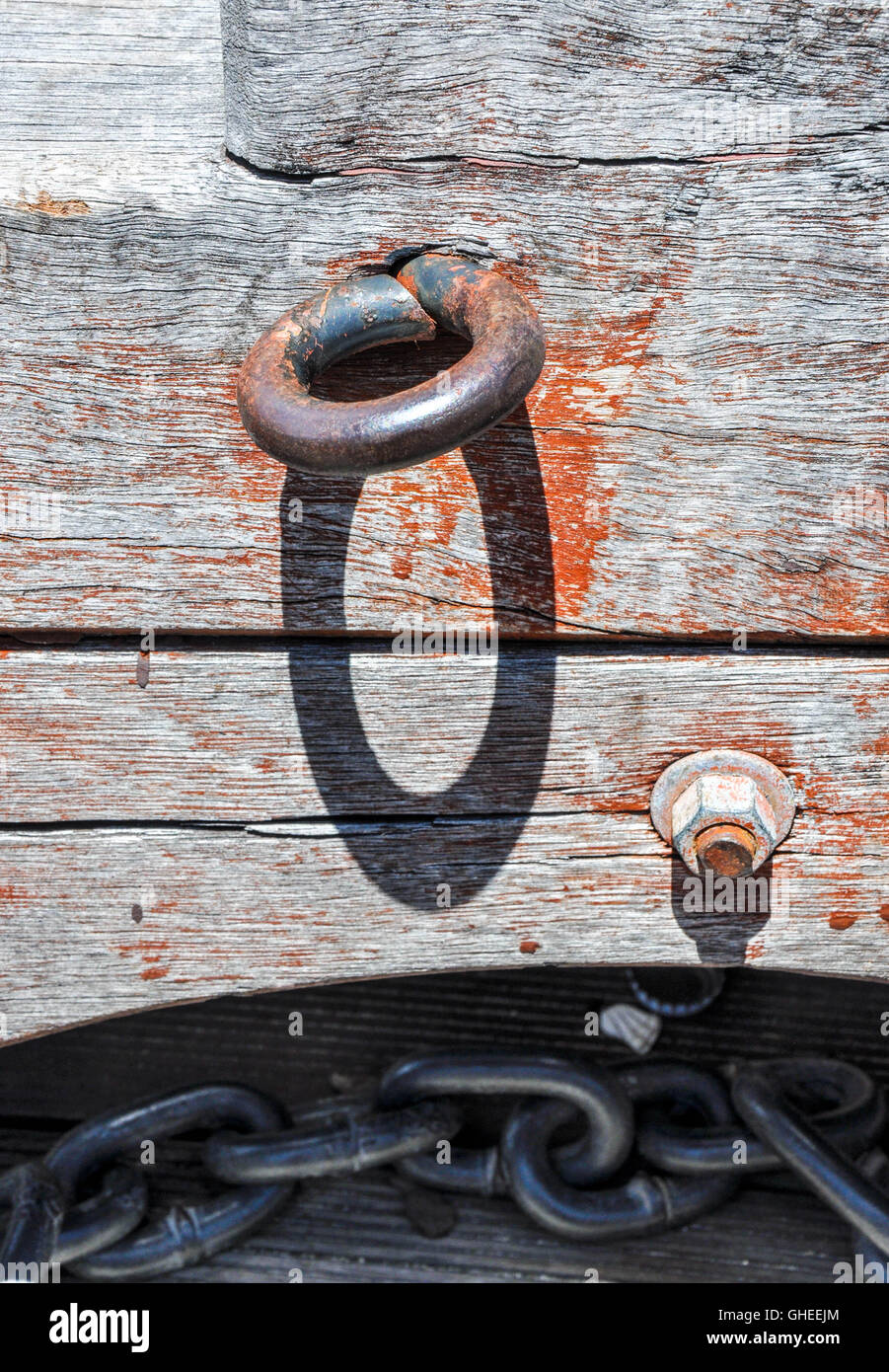 Closeup of rusty eye bolt with shadow with a rustic painted wood ...