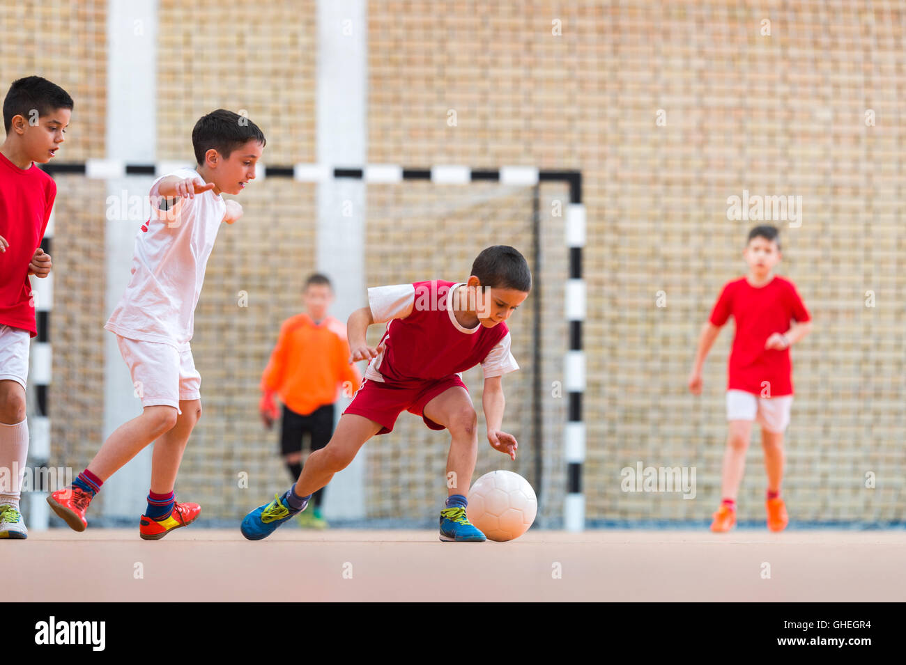 Boys kicking ball at goal Stock Photo - Alamy