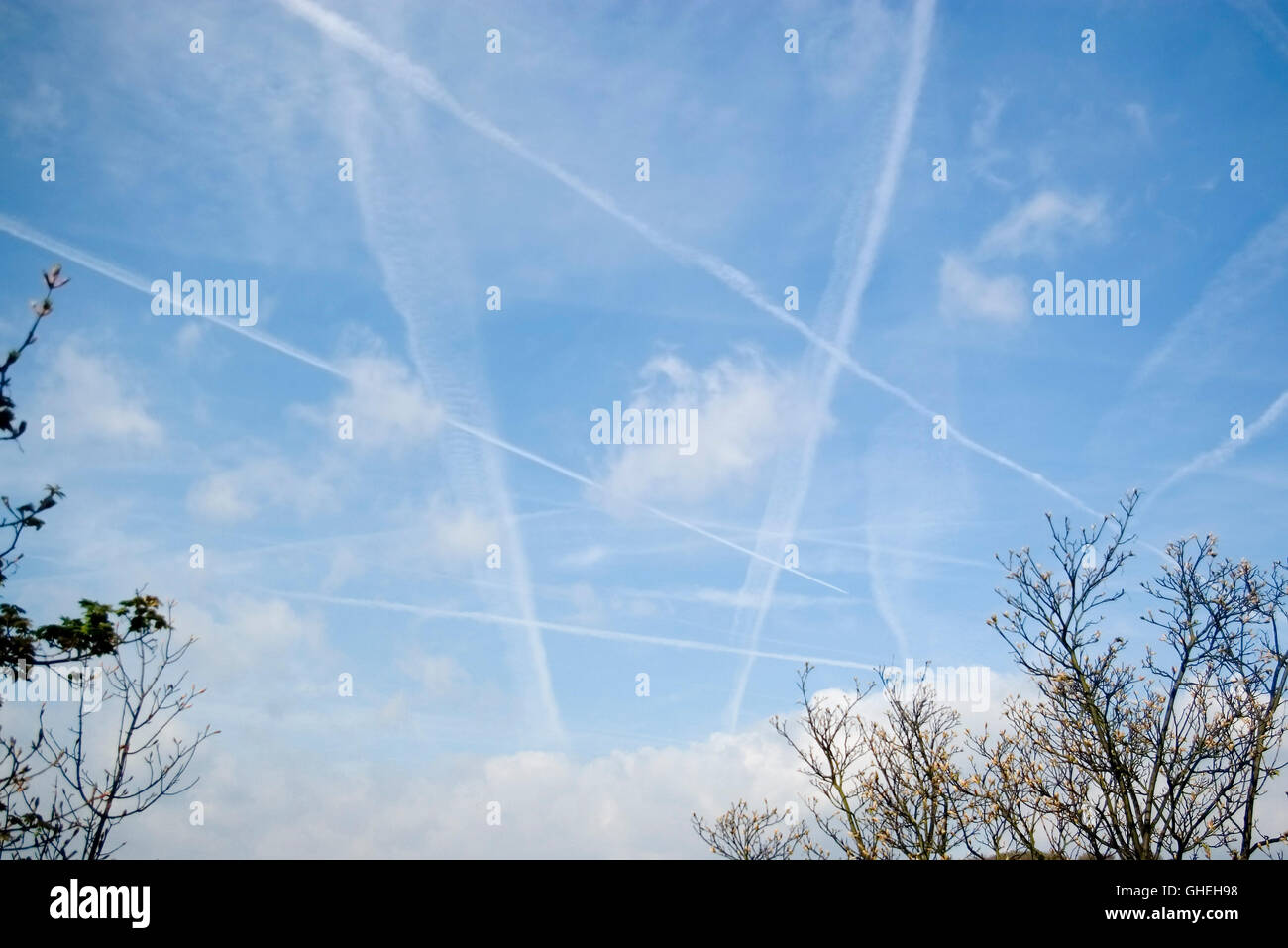 Criss-crossing jet trails in the summer sky Stock Photo - Alamy