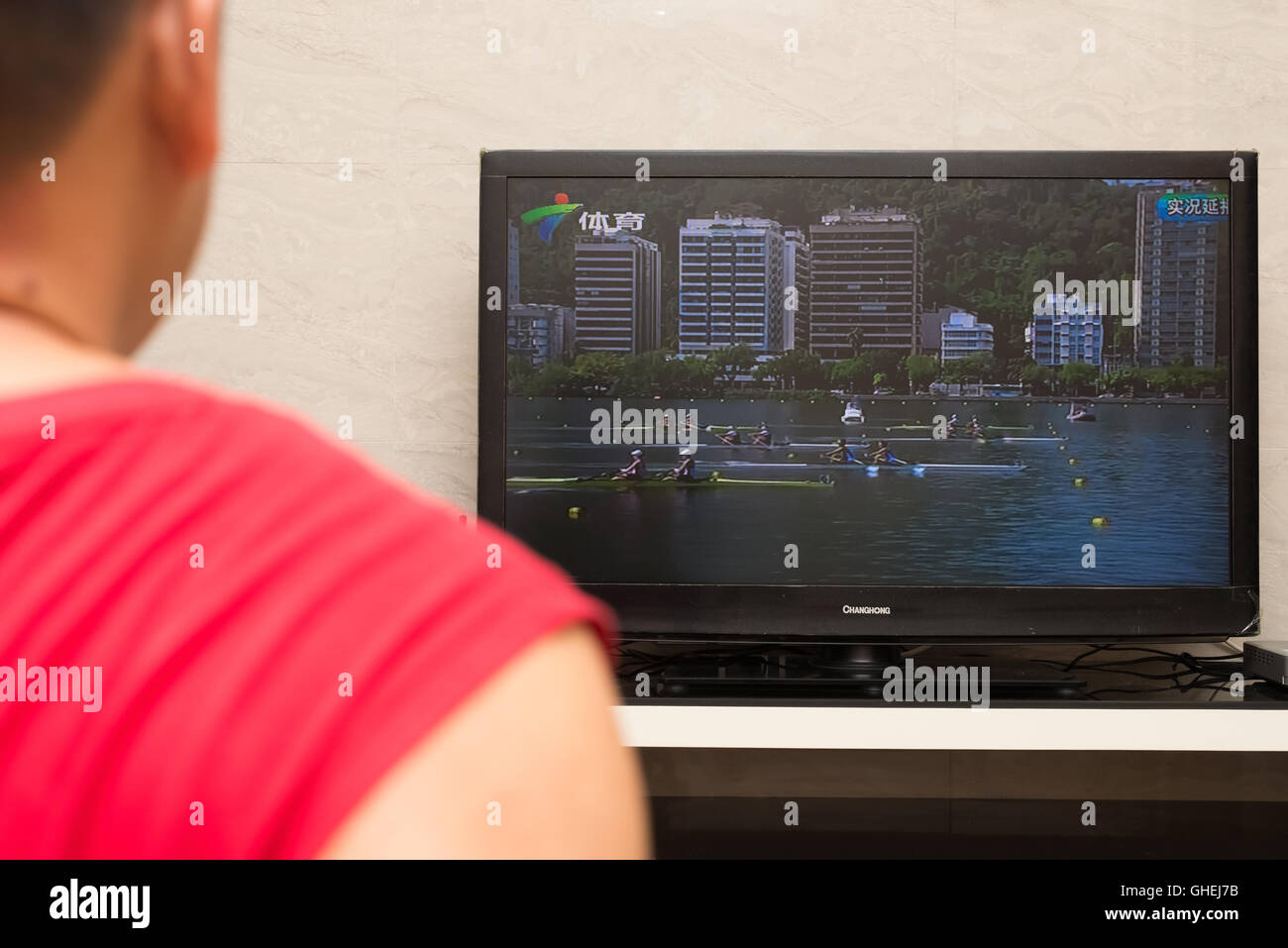 ZHONGSHAN CHINA-August 9:a Chinese watching TV broadcasting rowing ...