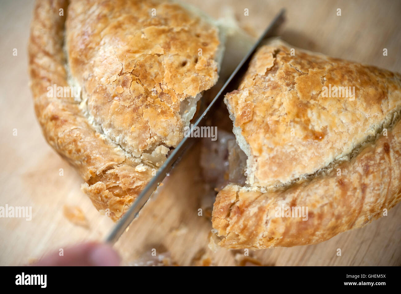 Cutting into a traditional Cornish pasty with a steel and bone-handled ...