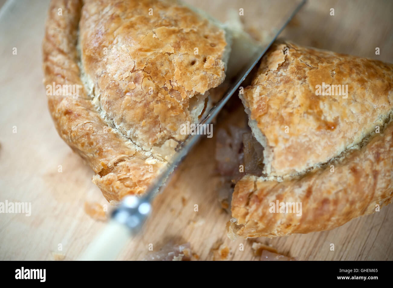 Cutting into a traditional Cornish pasty with a steel and bone-handled ...
