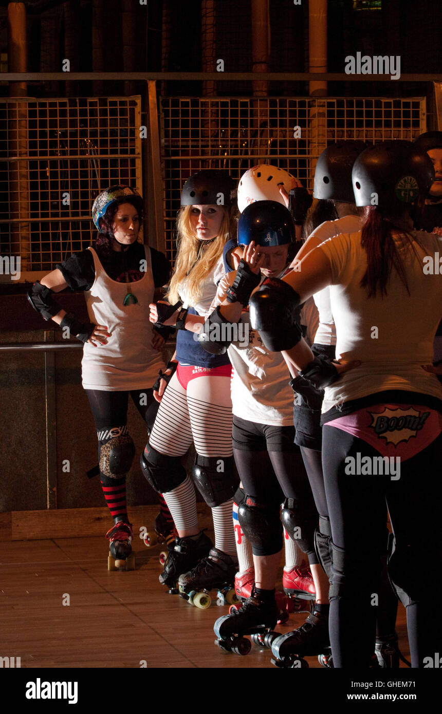 Dramatically lit roller derby skaters line up on practice night Stock ...