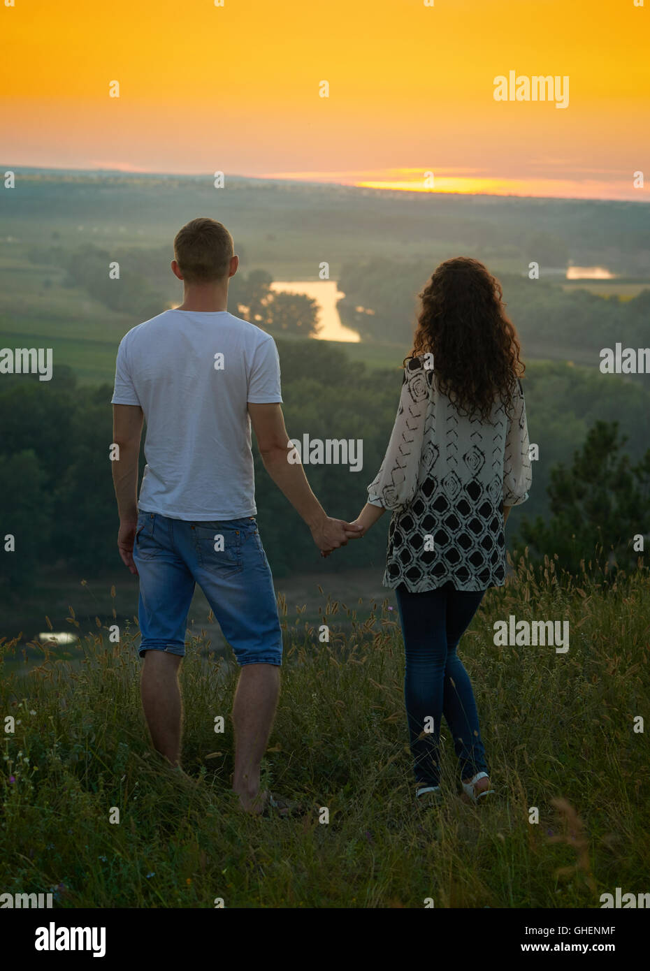 romantic couple looking into the distance at sunset on outdoor ...