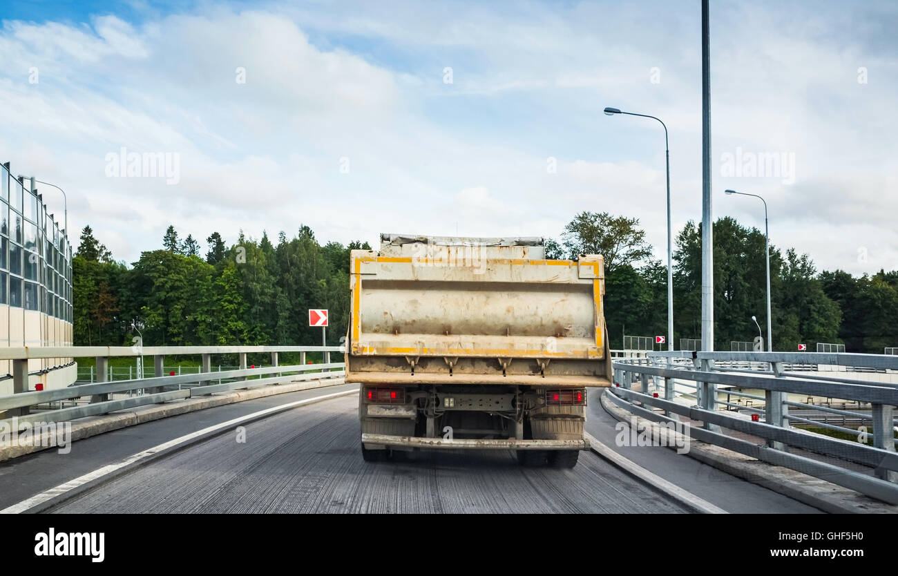 Big industrial tipper truck goes on asphalt road, rear view Stock Photo ...