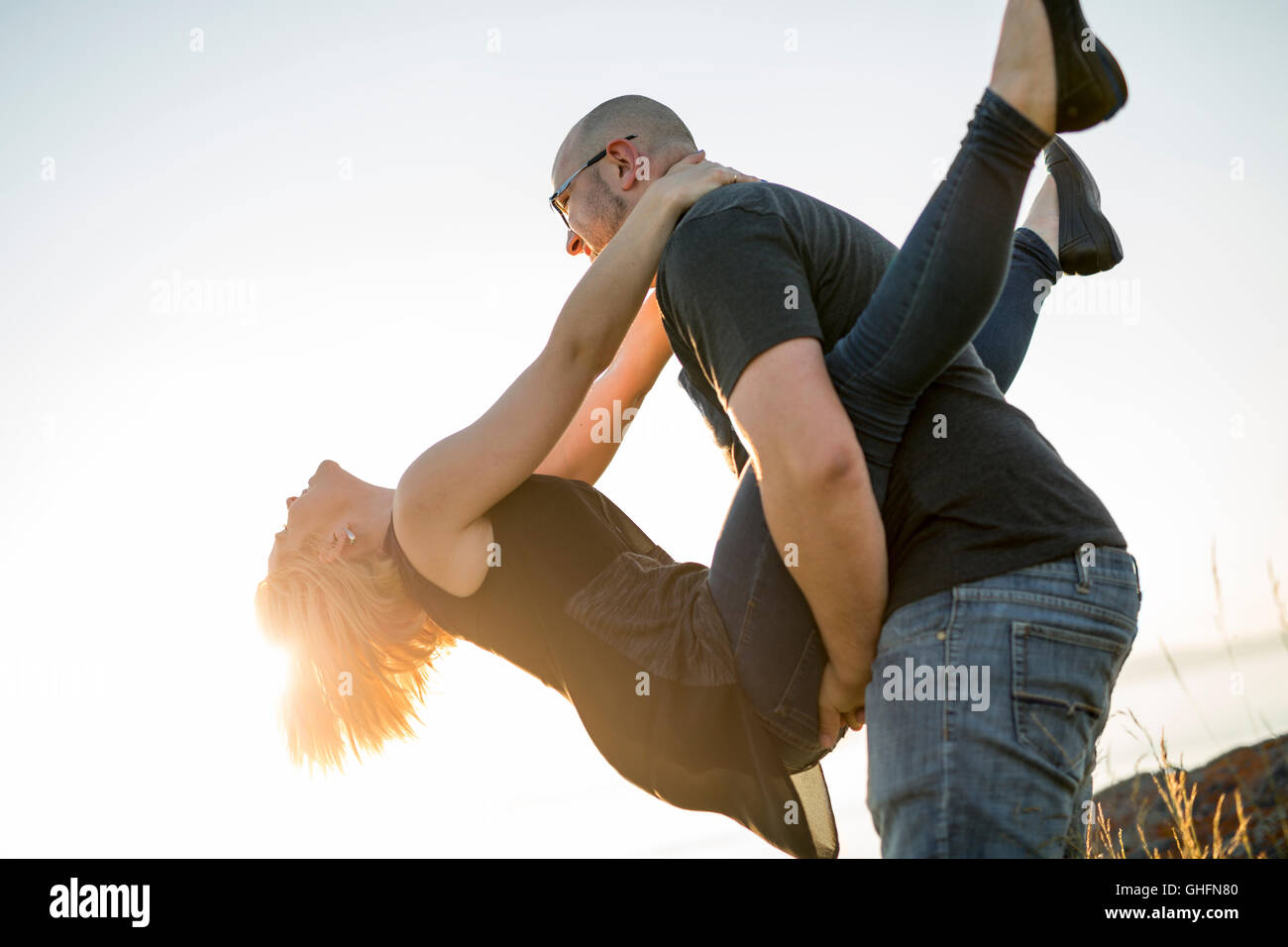 Beautiful couple at the sunset habing fun on seaside Stock Photo - Alamy