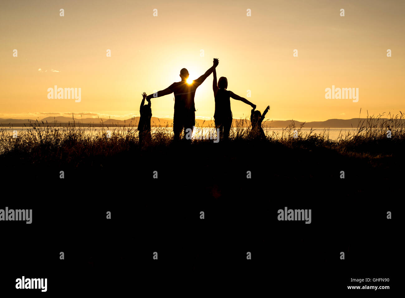 family of four at sunset shadow black backlit Stock Photo - Alamy