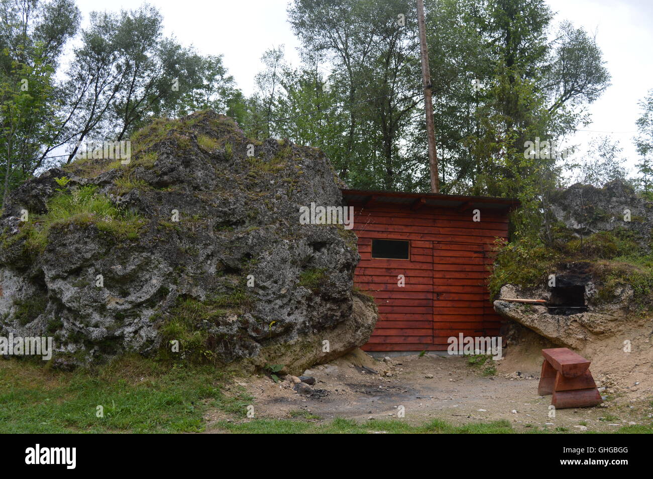 Small wooden house built between rocks Stock Photo - Alamy