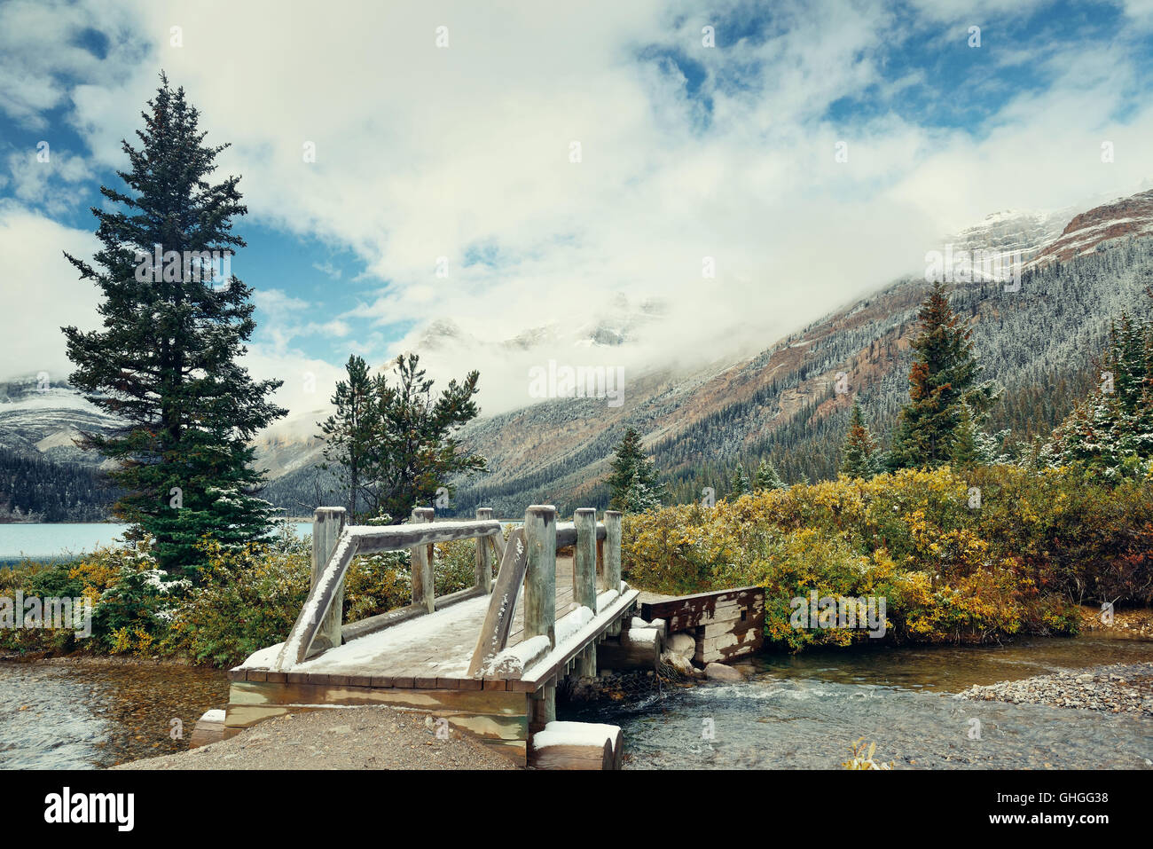 Wood bridge with snow capped mountain and forest in Banff National Park ...