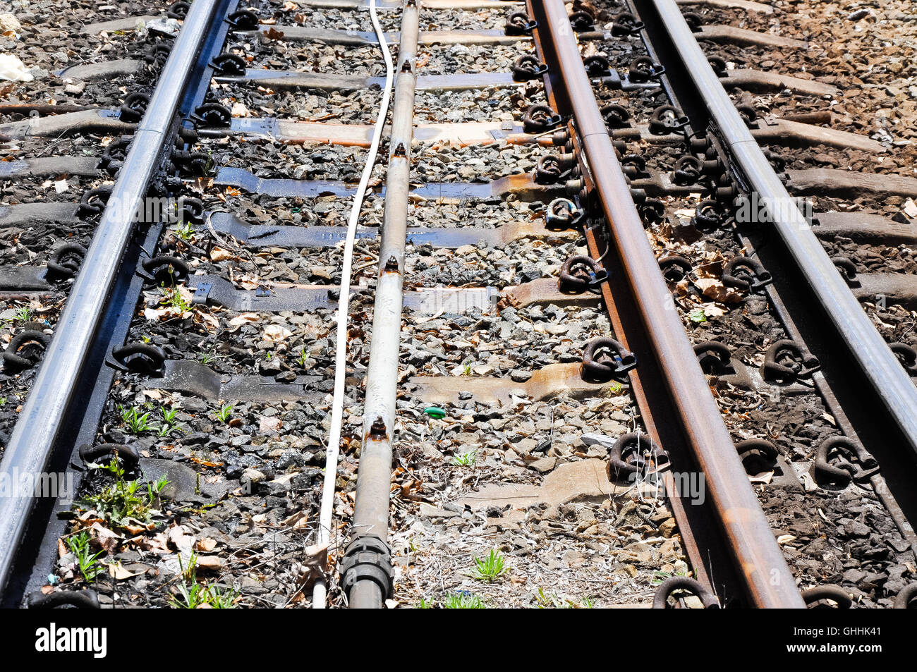 Closeup of railway steel rails with railroad ties and rock bed in the ...