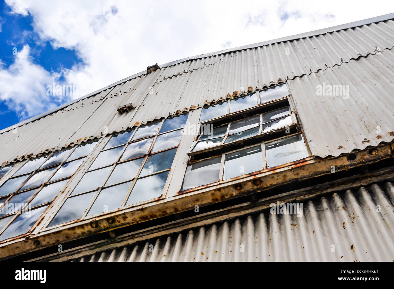 Upward perspective of old rusted metal pole building with windows under ...