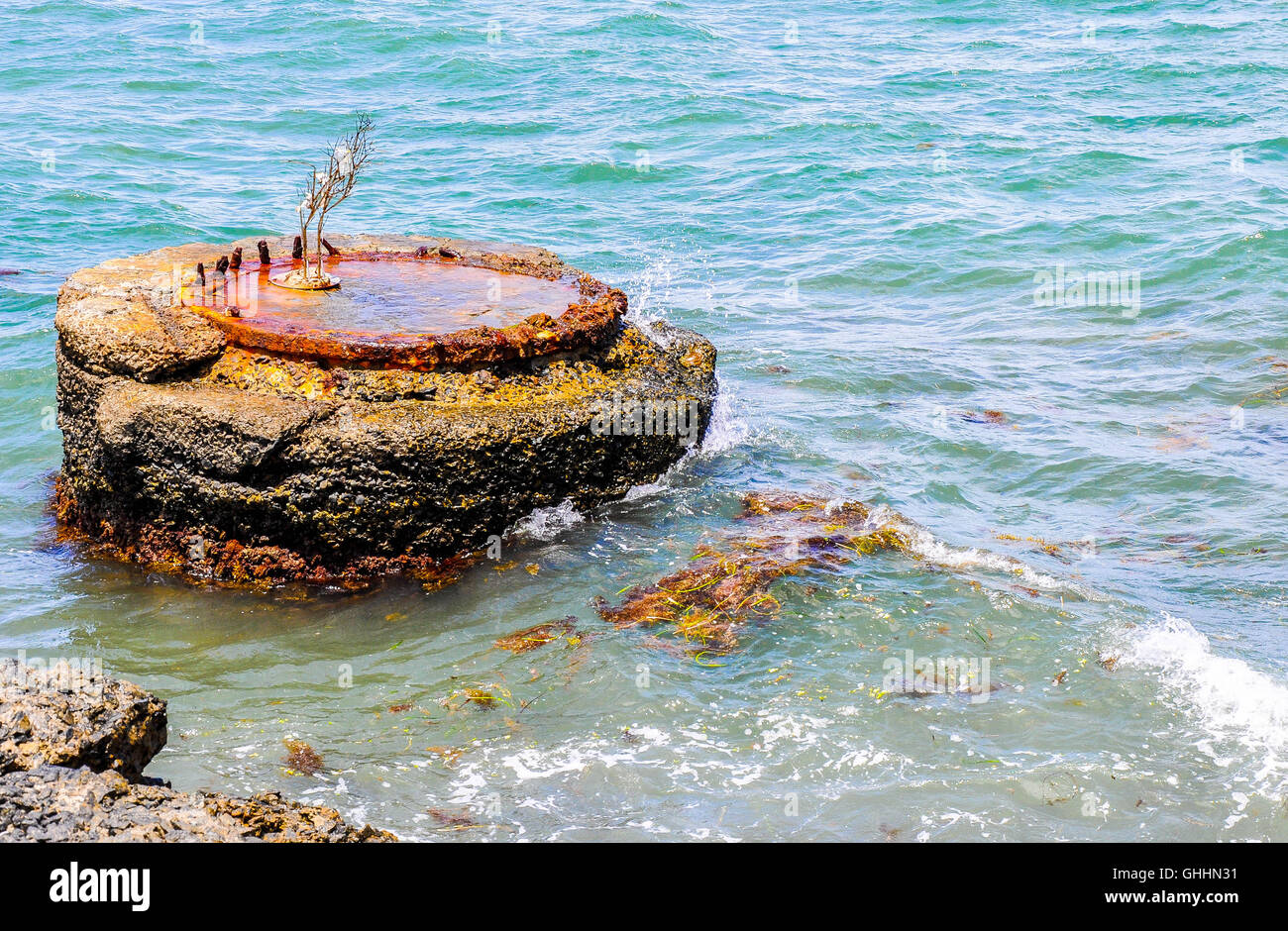 Concrete buoy with rusted metal disc on top in the turquoise Indian ...