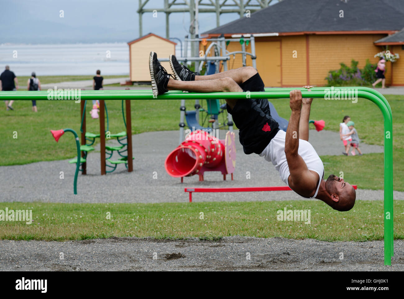 A man exercising on parallel bars in a park Stock Photo - Alamy