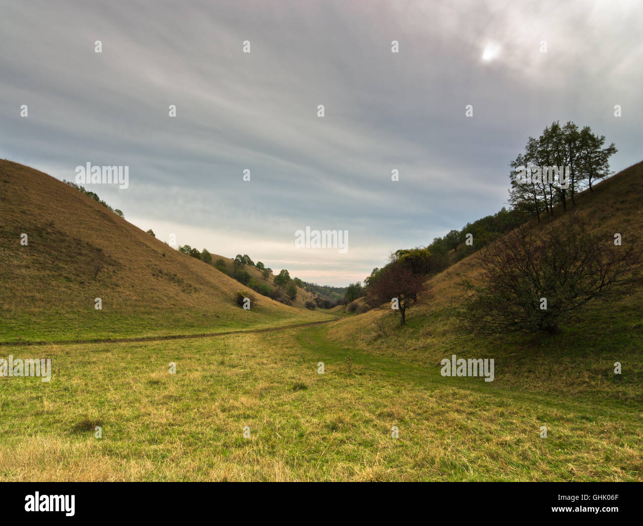 Valley between small hills under dark clouds Stock Photo - Alamy