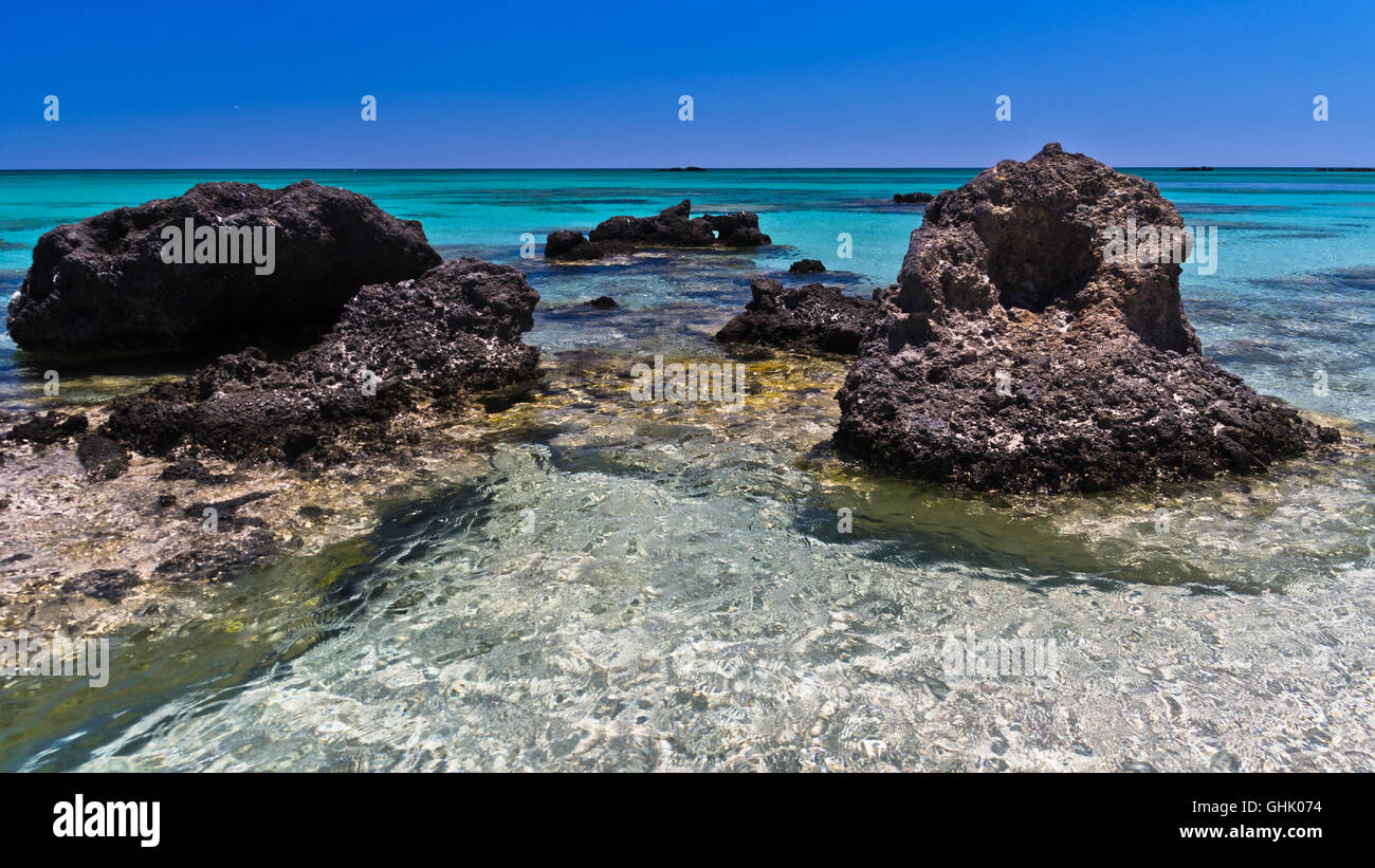 Black rocks and turquoise water at Elafonisi beach, island of Crete ...