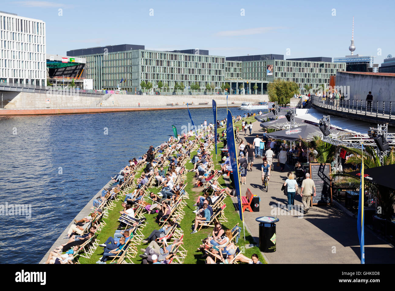people relaxing on deck chairs by the Spree river at Capital Beach Bar ...