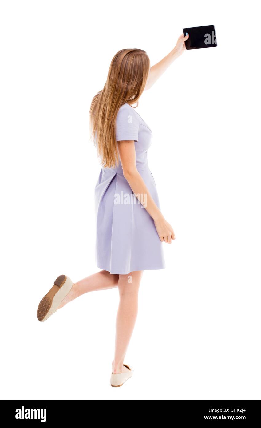 back view of standing young beautiful woman in vest and using Stock ...