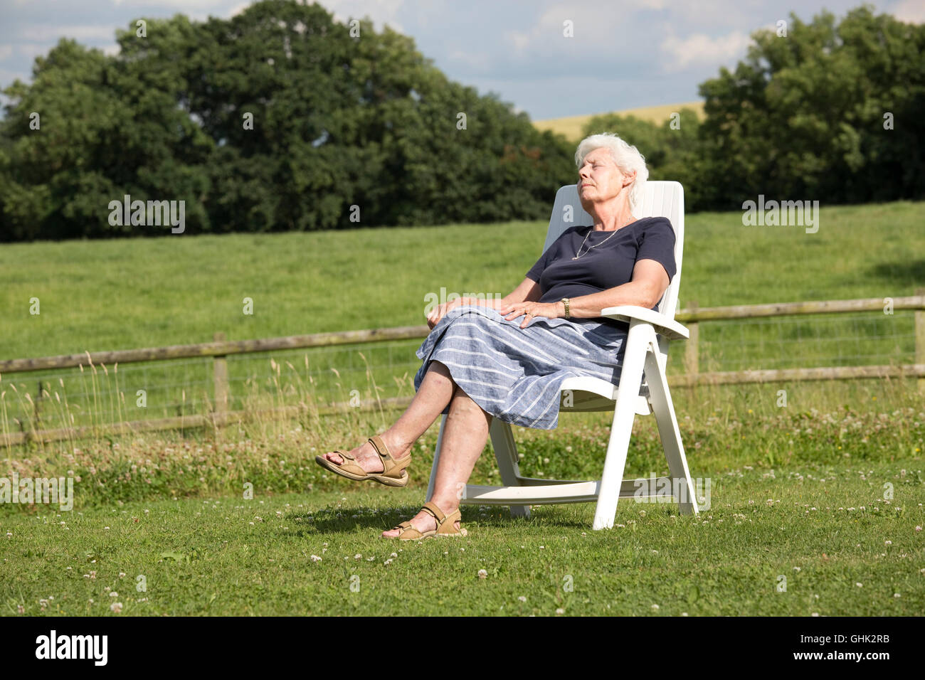 Senior woman in chair napping outside in field UK Stock Photo - Alamy