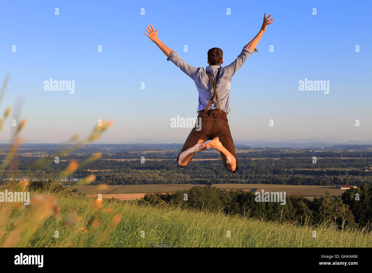 A German Man in Bavarian dress jumping happily on lawn Stock Photo - Alamy