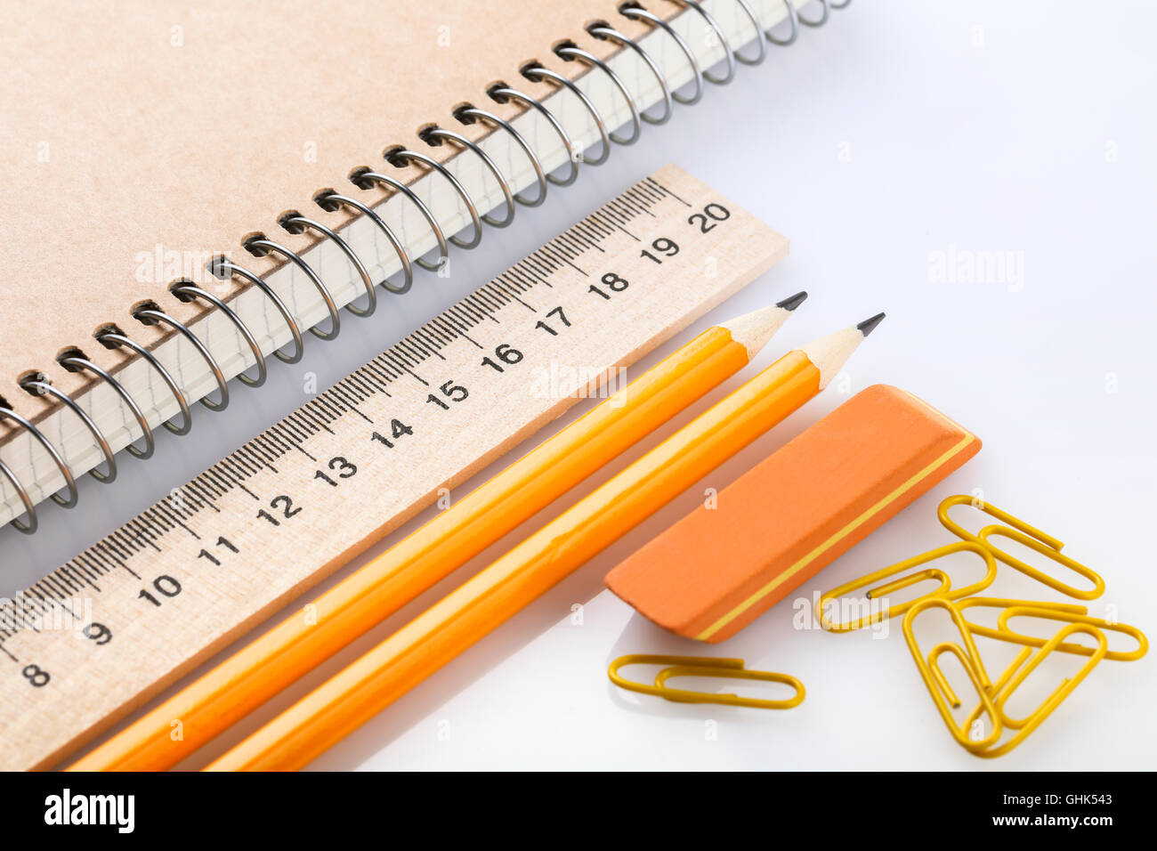 notebook, eraser, ruler, pencil and paperclips on white background ...