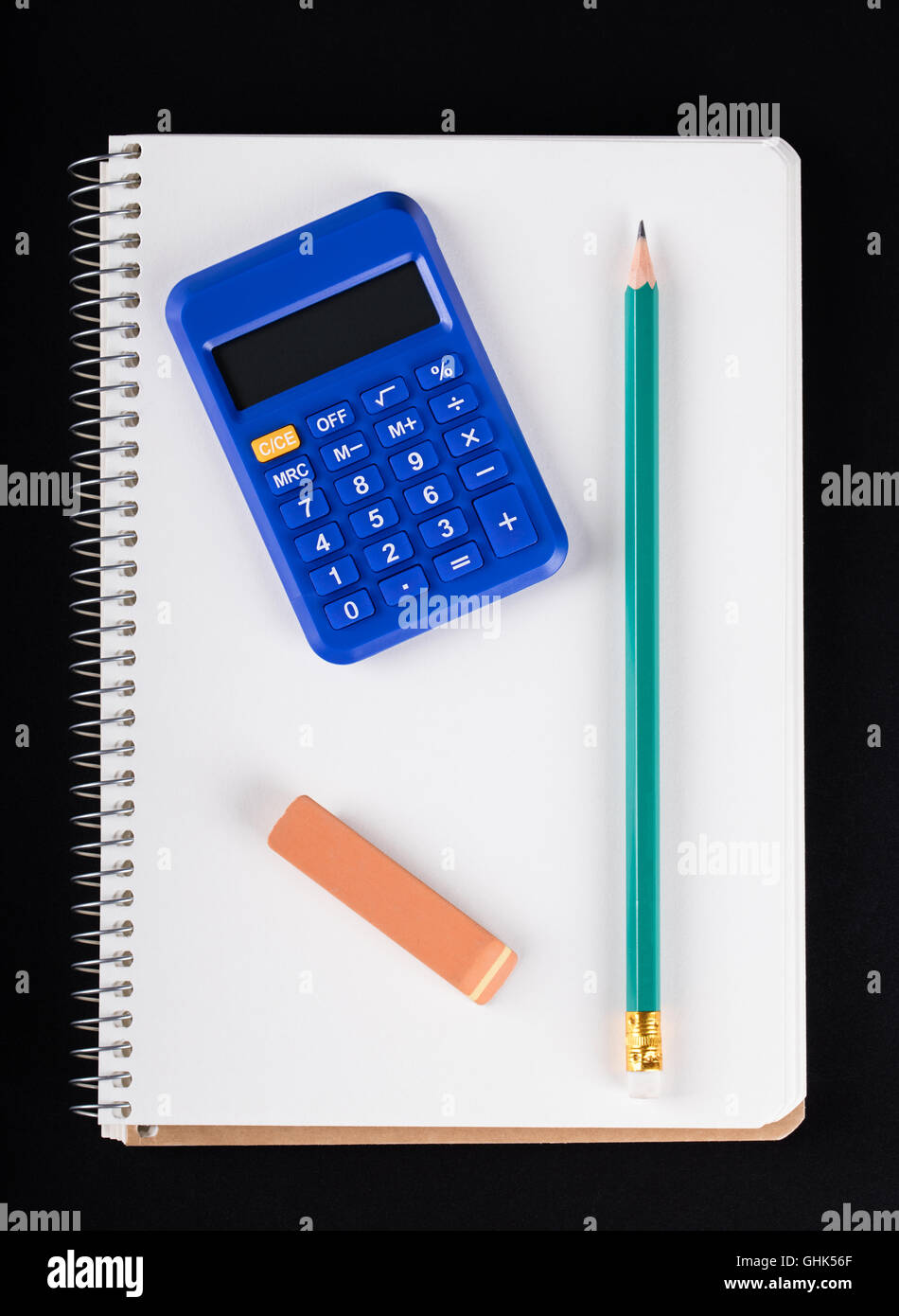 notebook, calculator, eraser and pencil on a black background Stock ...