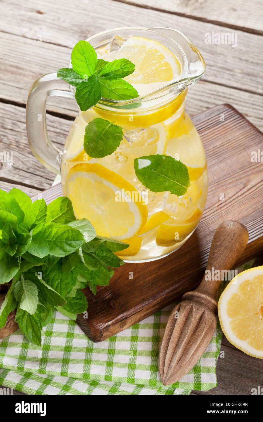 Lemonade pitcher with lemon, mint and ice on garden table Stock Photo ...