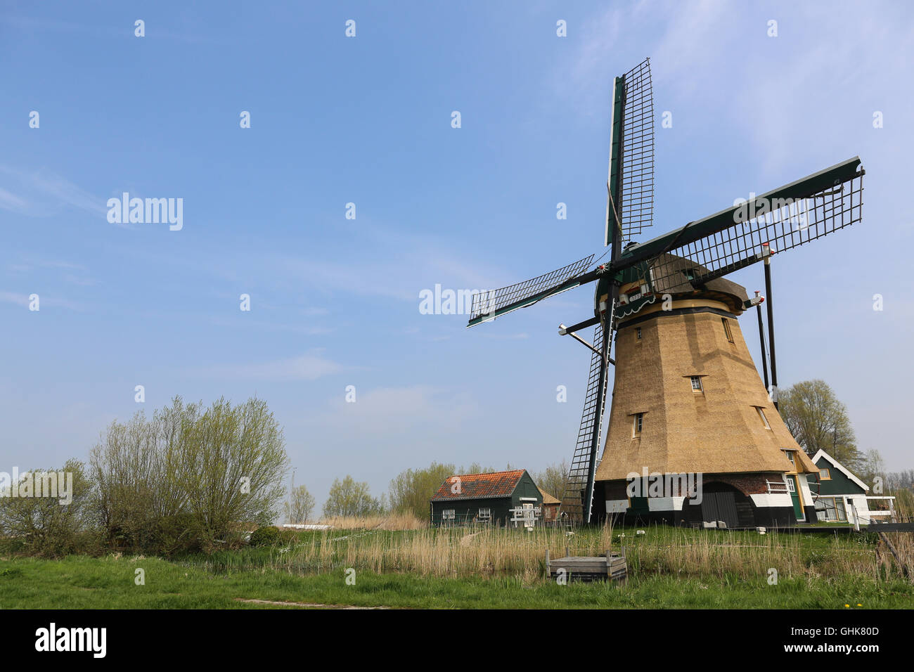 Dutch windmill with a bridge over water and a path in a dutch landscape ...