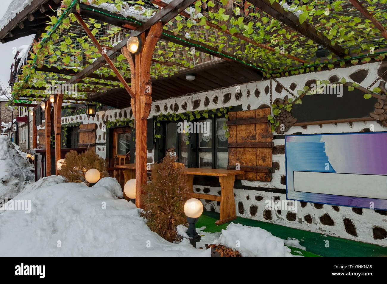 Snow winter street in the Bansko town with ancient houses and vine ...