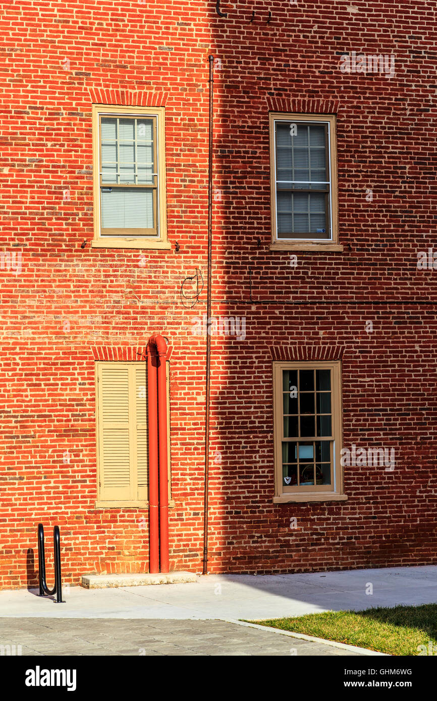 Red Brick Building Split with Shade Stock Photo - Alamy
