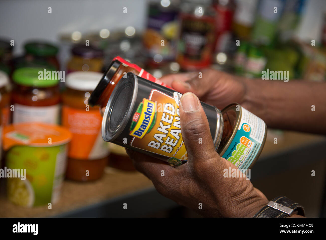 A man collecting a tin of baked beans from a shelf at the North ...