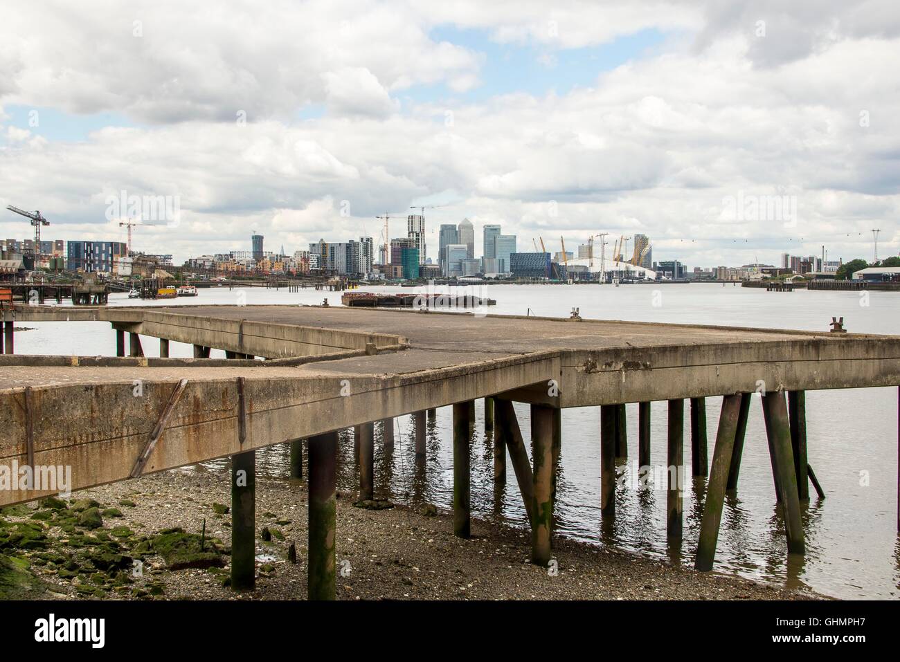 Wooden dock on river Thames at low tide with O2 Center and Canary Wharf ...