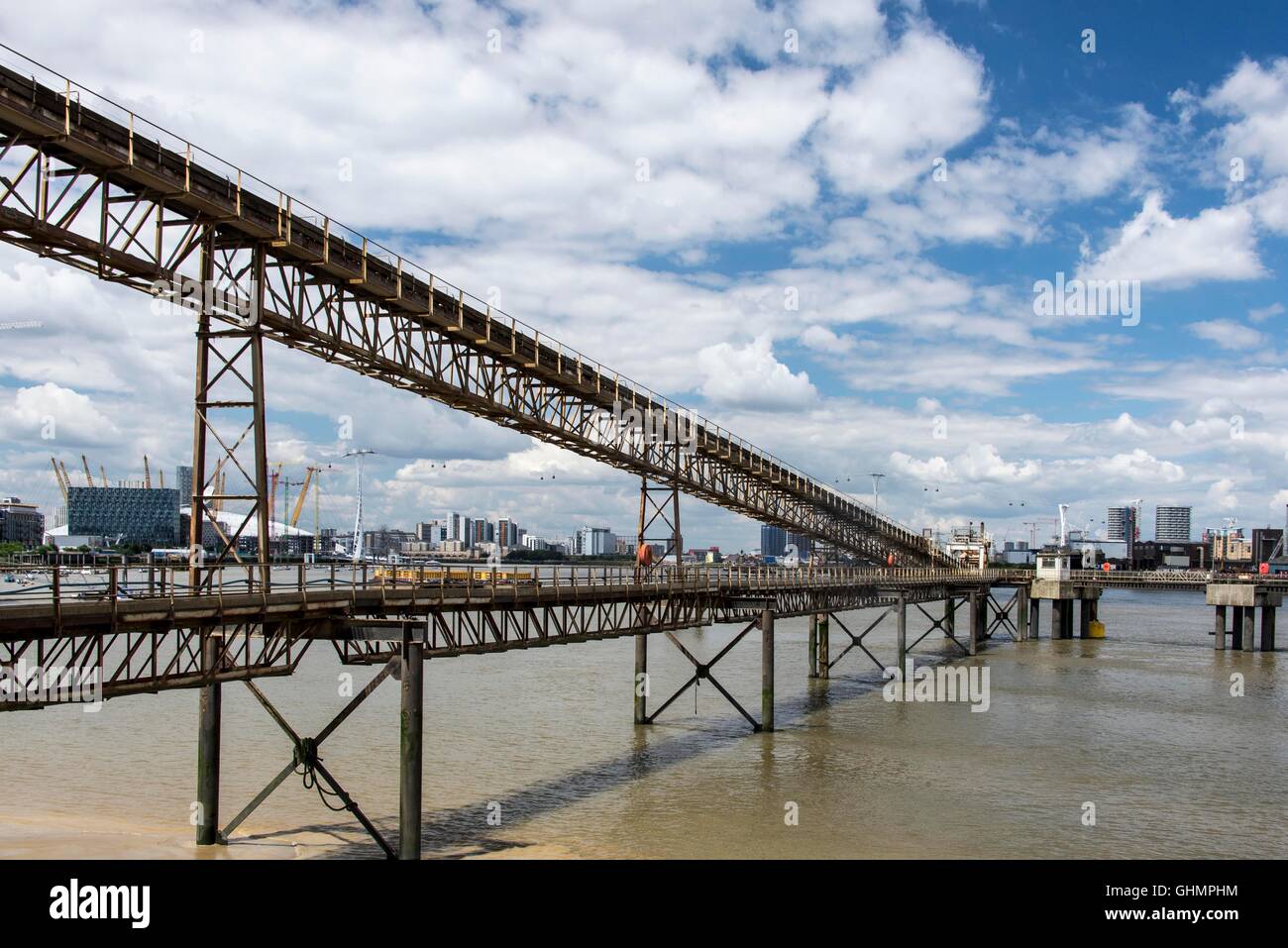 Gravel aggregates conveyor belt extending over river from dredger dock ...