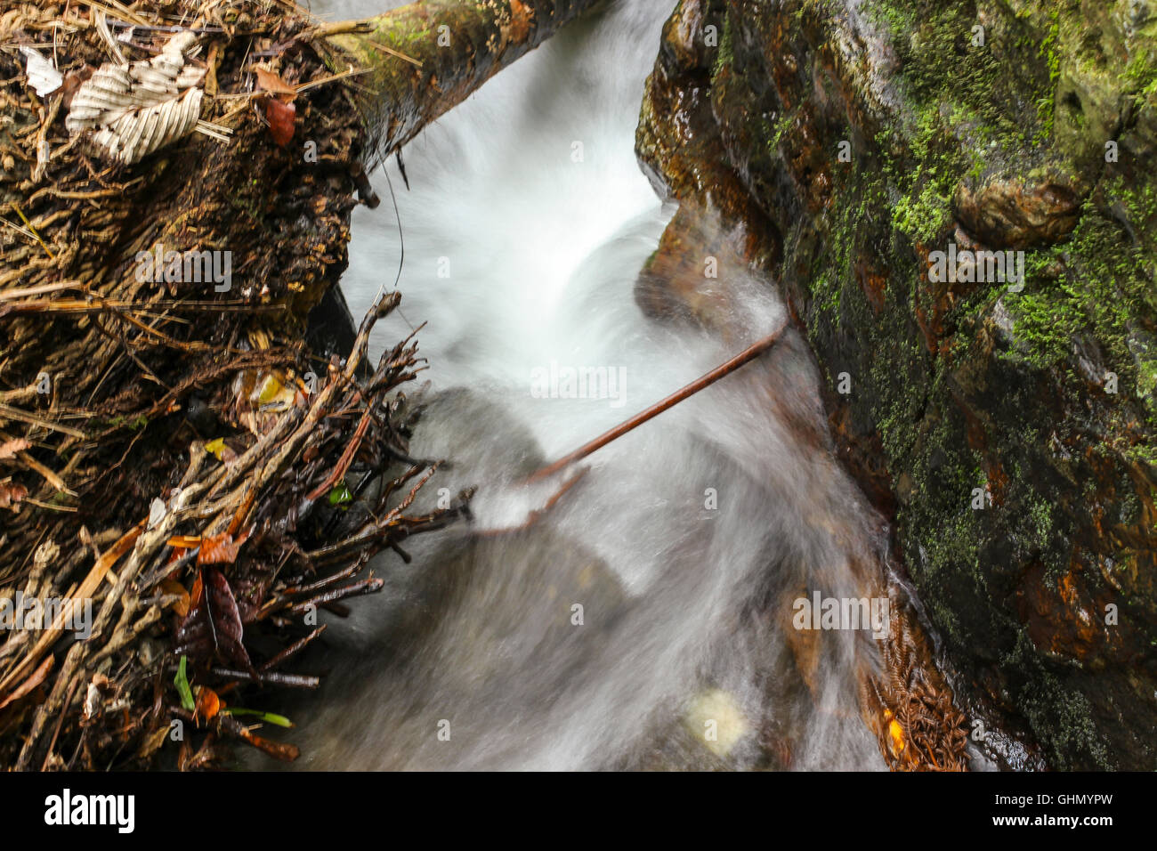 Silky water stream moving through rocks Stock Photo - Alamy