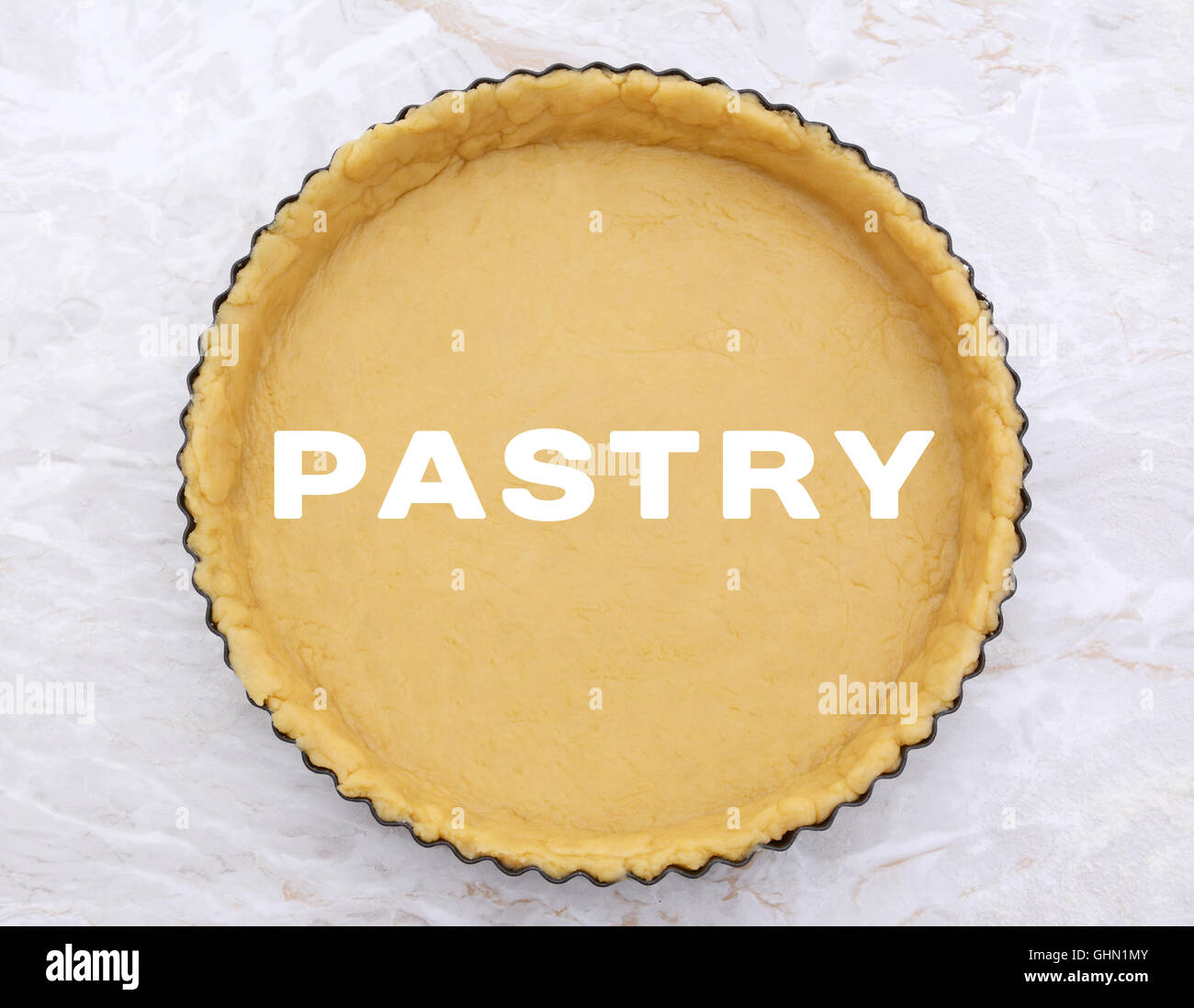 PASTRY text written across shortcrust pastry lined metal tin on a ...