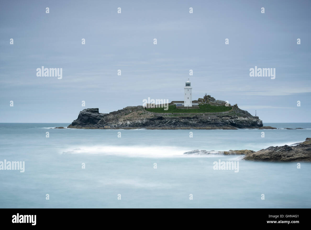 Long exposure of the rising tide on the rocks towards the lighthouse at ...