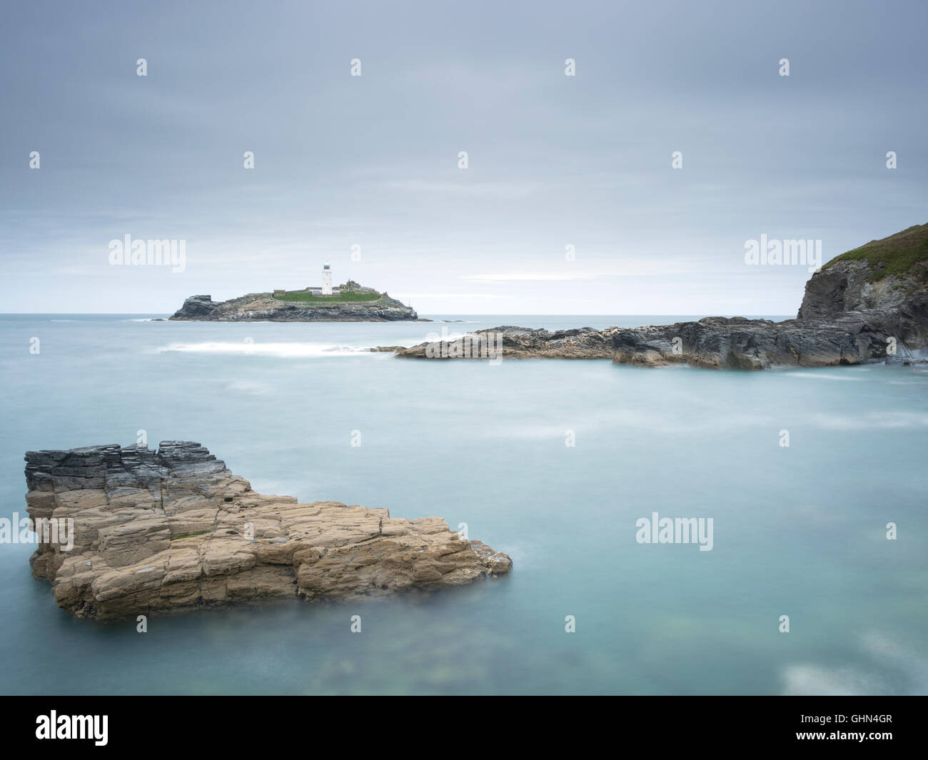 Long exposure of the rising tide on the rocks towards the lighthouse at ...