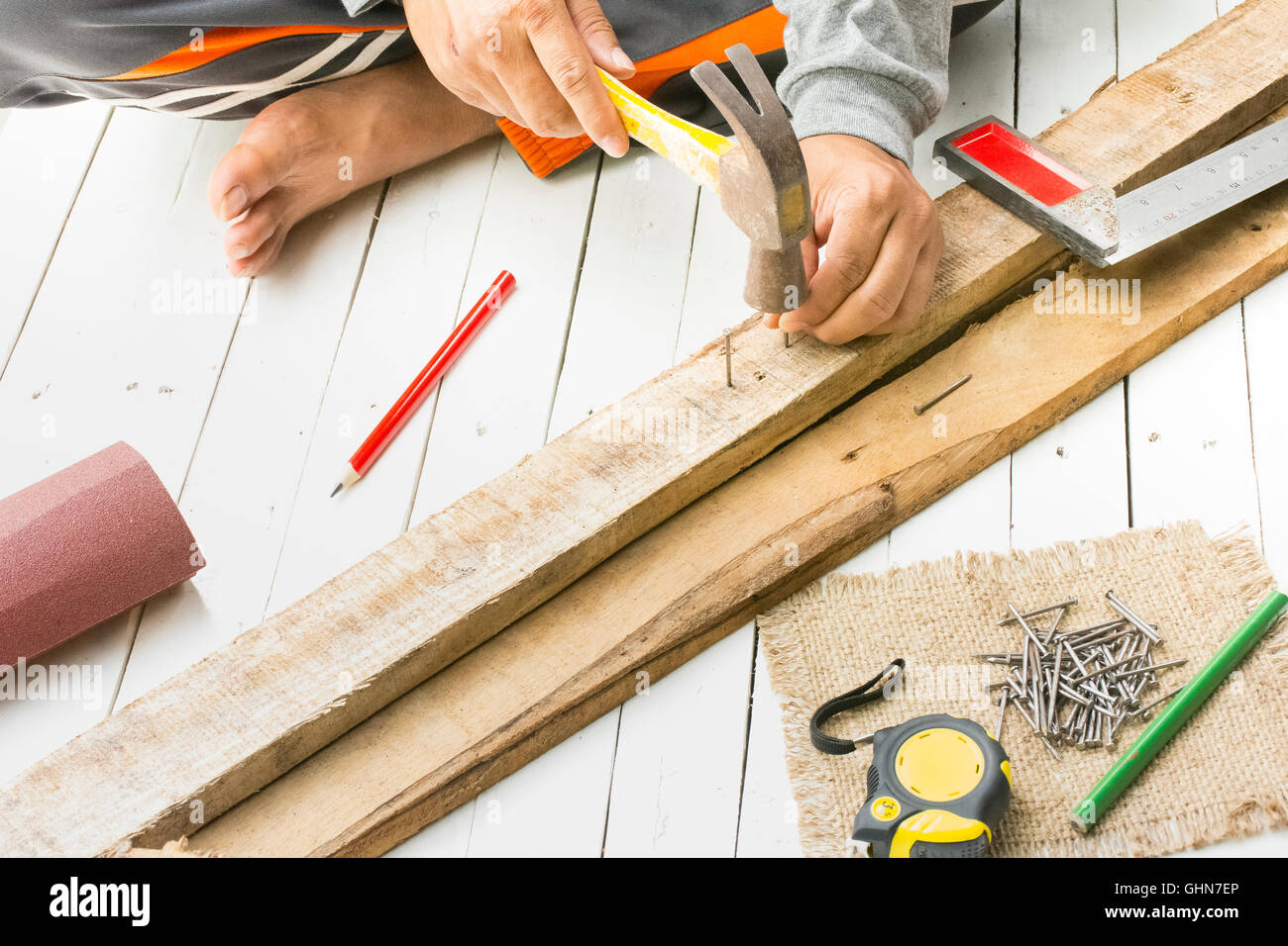 Male carpenter using hammer and nail at work place.Background craftsman ...