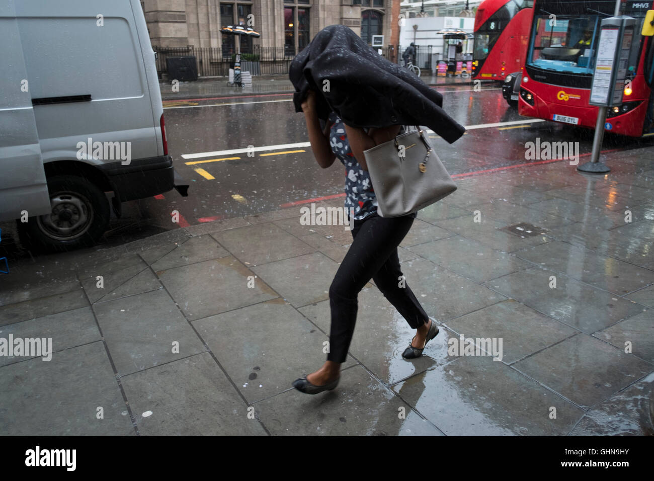 People running for cover or sheltering under umbrellas street scene in ...