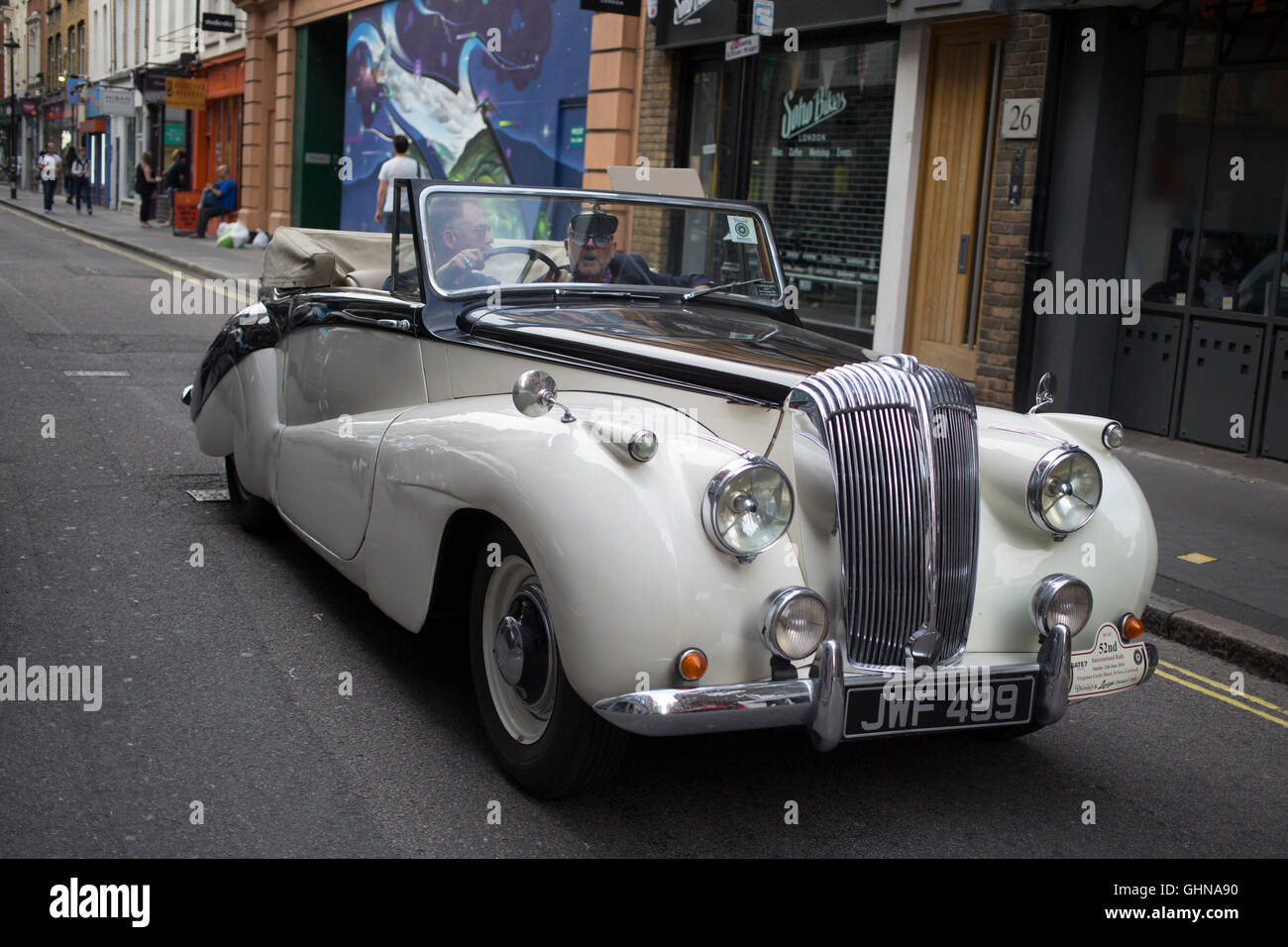 Vintage Daimler car driving along Berwick Street with passers by ...