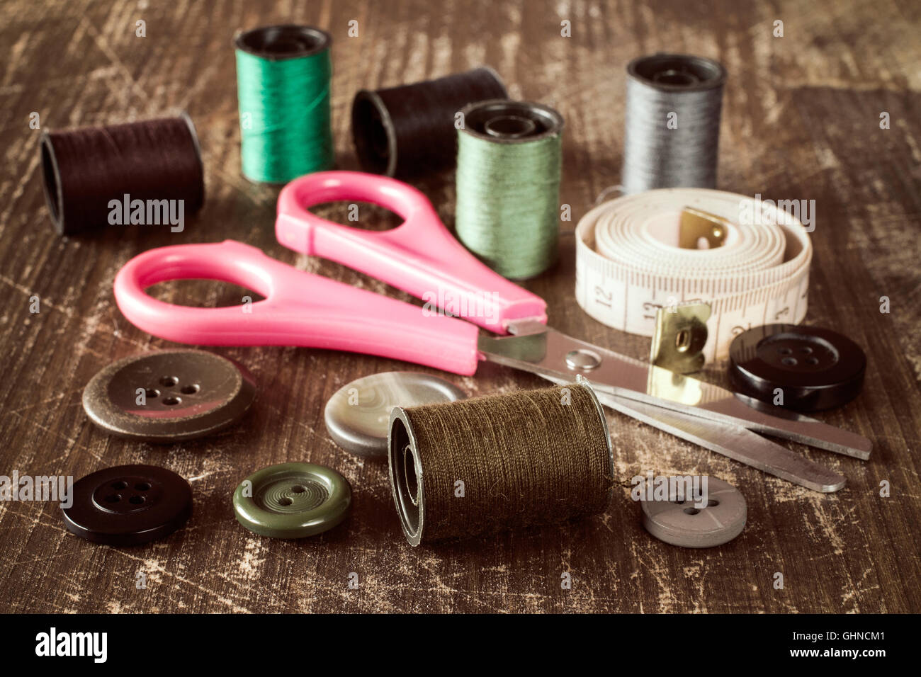 Tailor's tools - scissors, measuring tape,spools,buttons,etc. on wooden ...