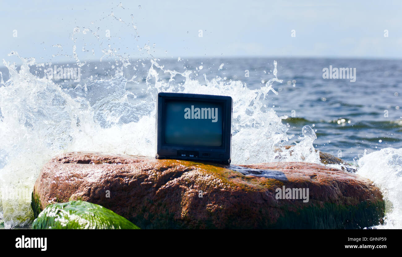 unusual photo of TV in ocean on stone Stock Photo - Alamy