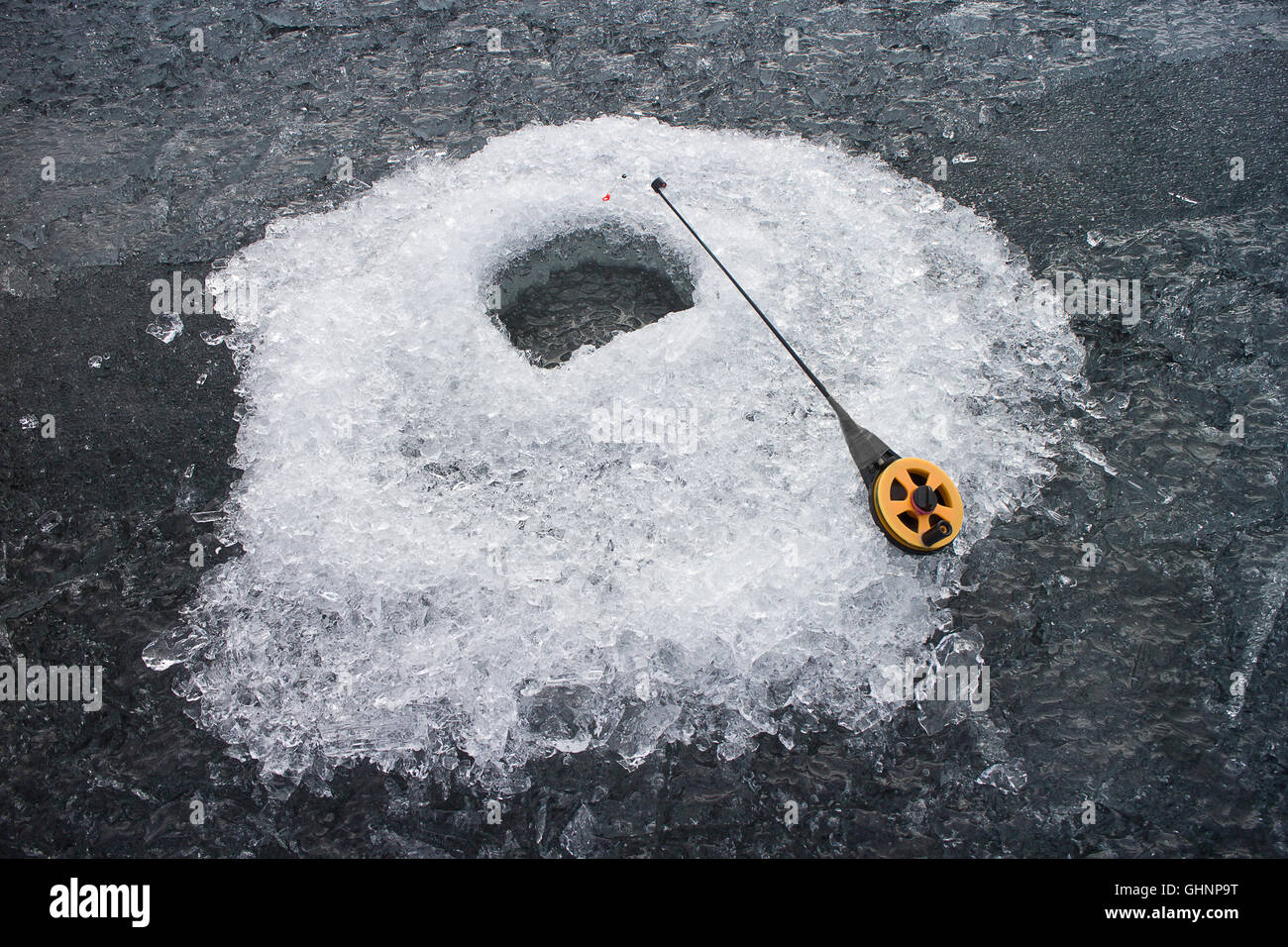 fishing rod for winter fishing on black ice Stock Photo - Alamy